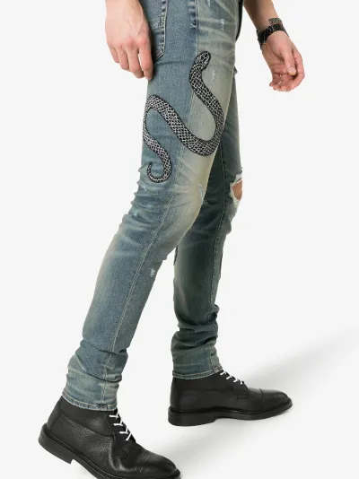 Amiri snake embroidered distressed jeans | Browns